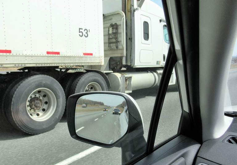 Why Do Some Semi Trucks Have a Tiny Window by the Passenger's Feet?