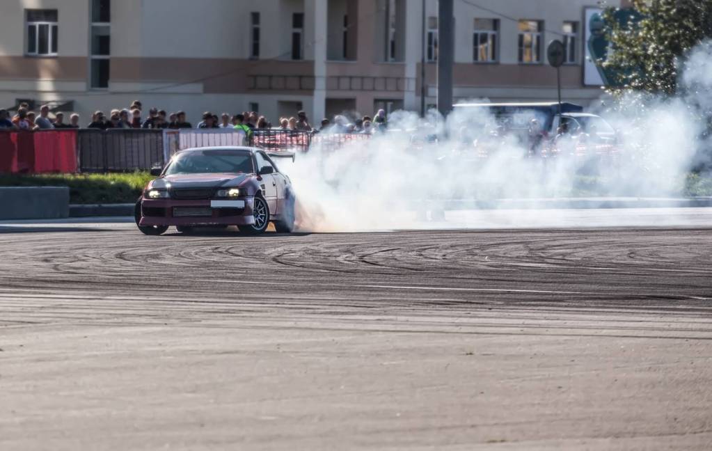 Watch this drift car cut it so close that it breaks a camera